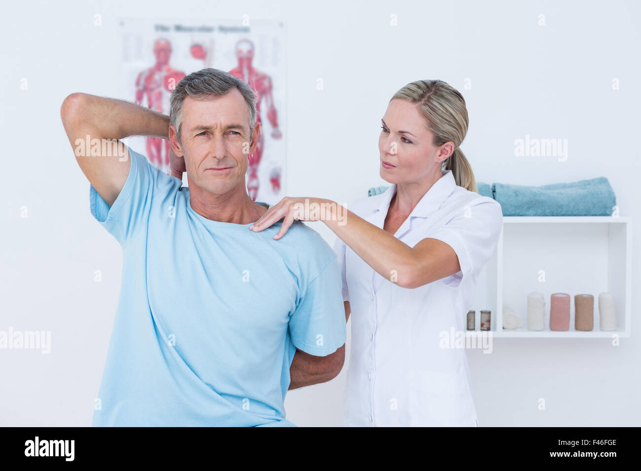 Doctor stretching a man arm Stock Photo - Alamy