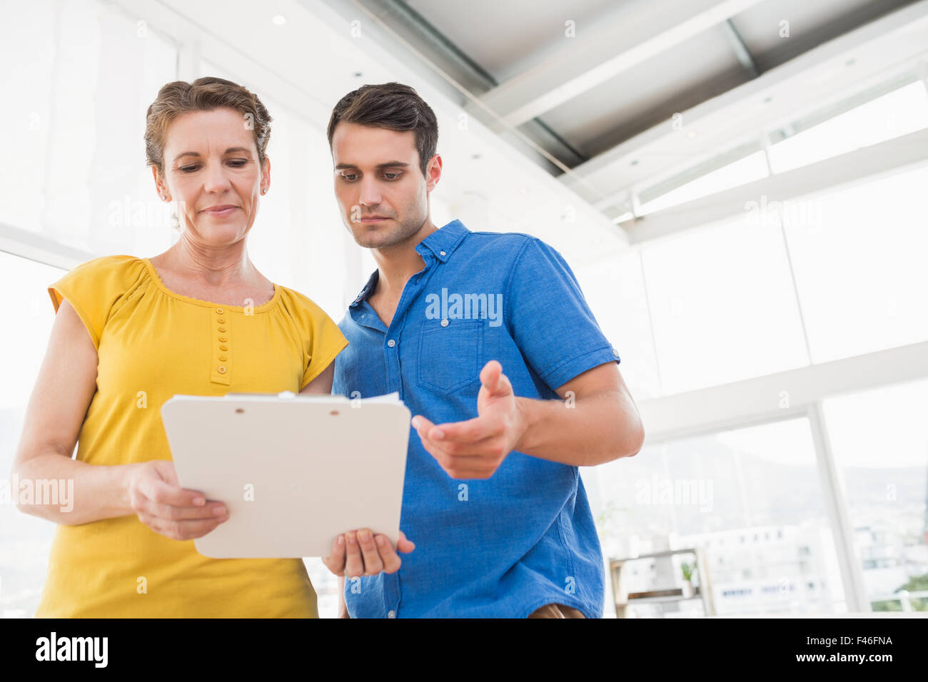Creative business people checking clipboard Stock Photo - Alamy