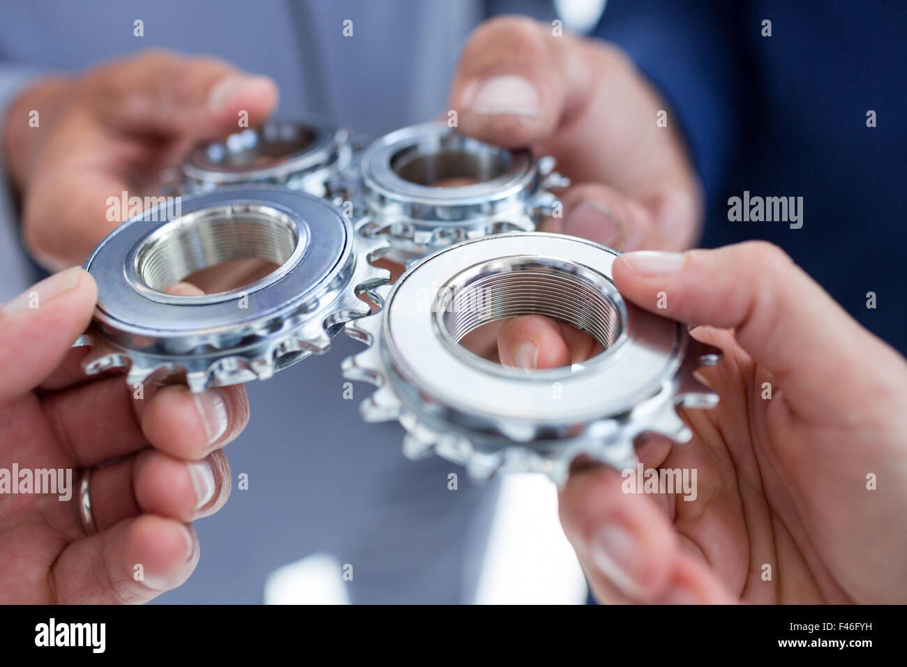 Business colleagues holding cog Stock Photo - Alamy