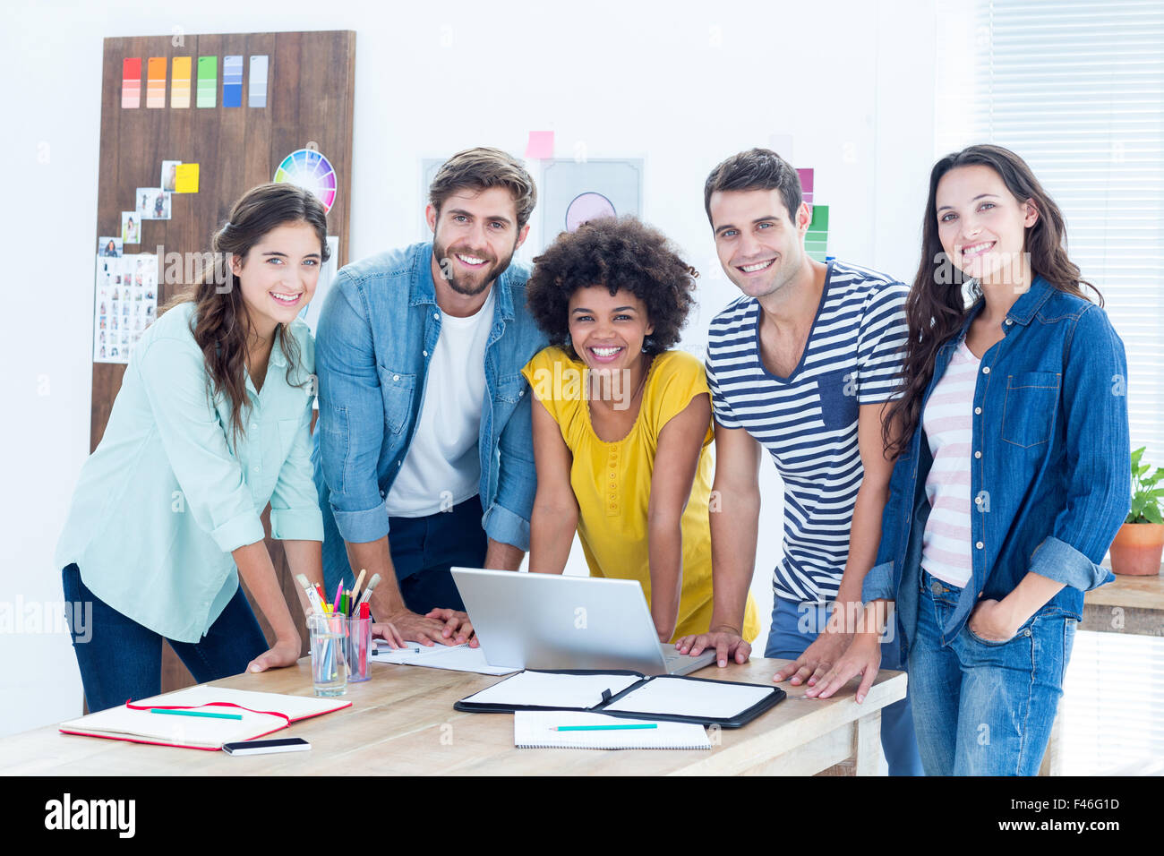 Group of young colleagues using laptop Stock Photo - Alamy