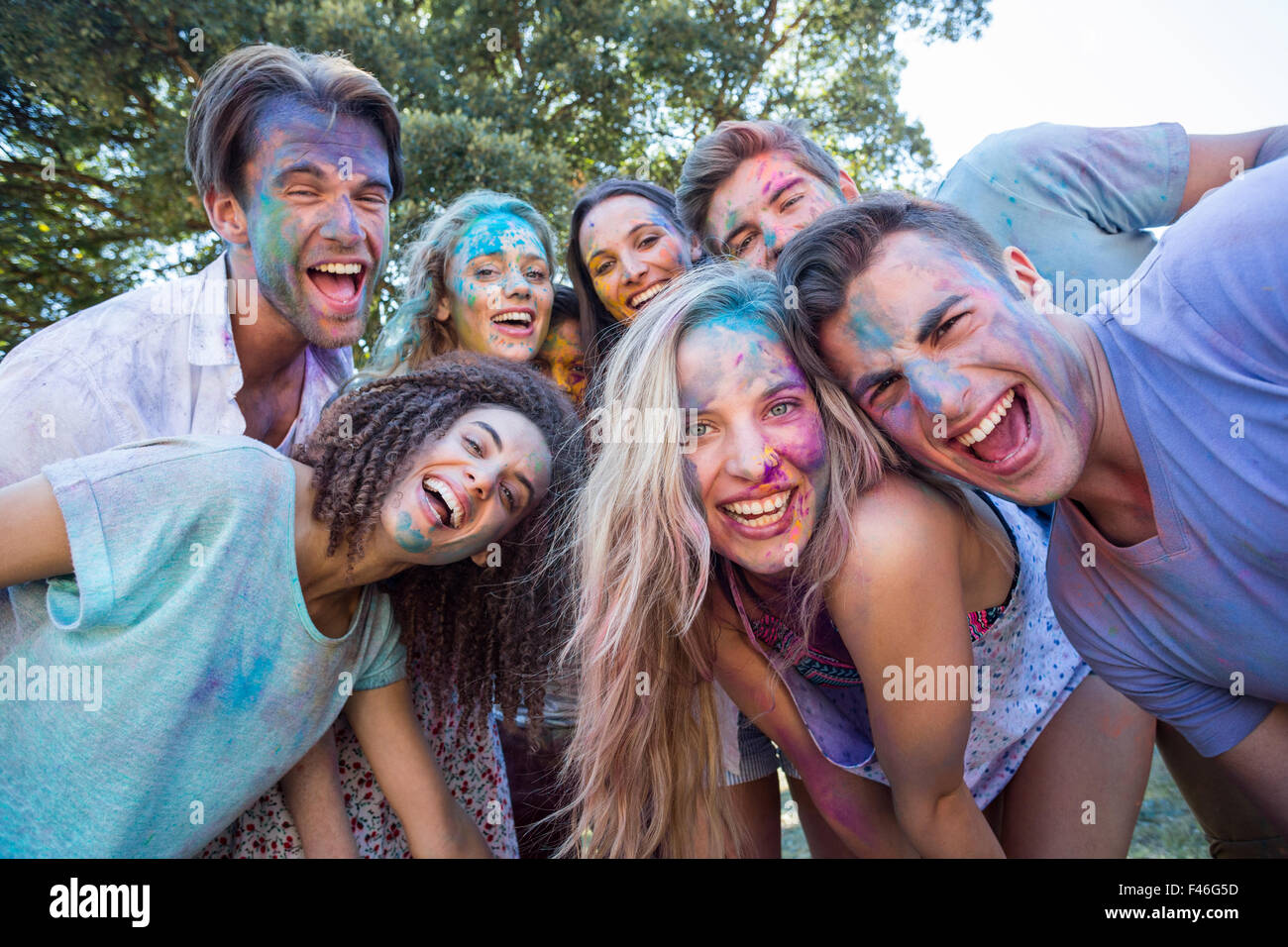 Happy friends covered in powder paint Stock Photo - Alamy