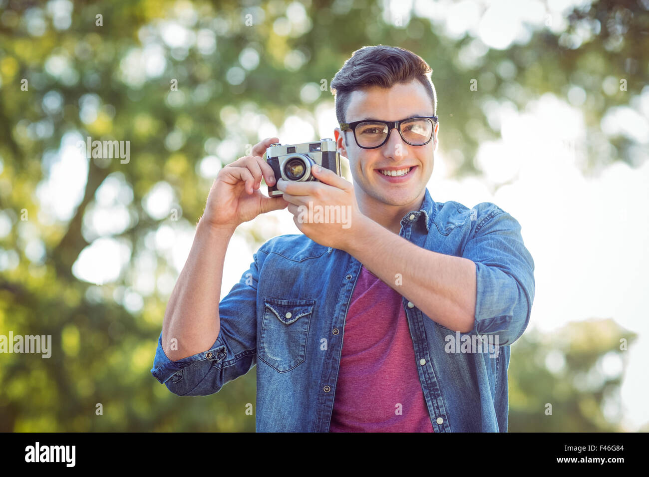 Handsome hipster using vintage camera Stock Photo - Alamy