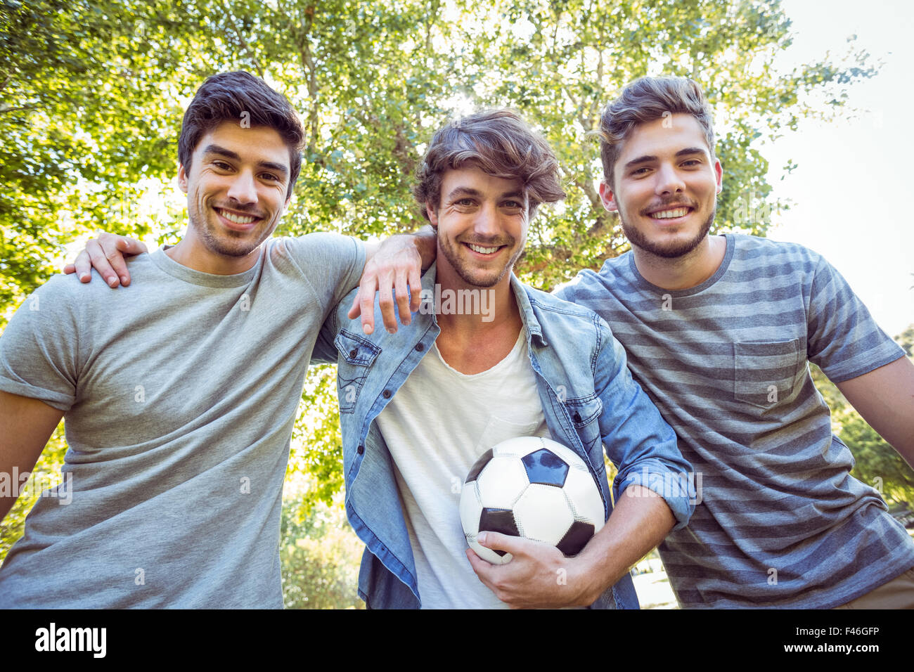 Happy friends in the park with football Stock Photo - Alamy