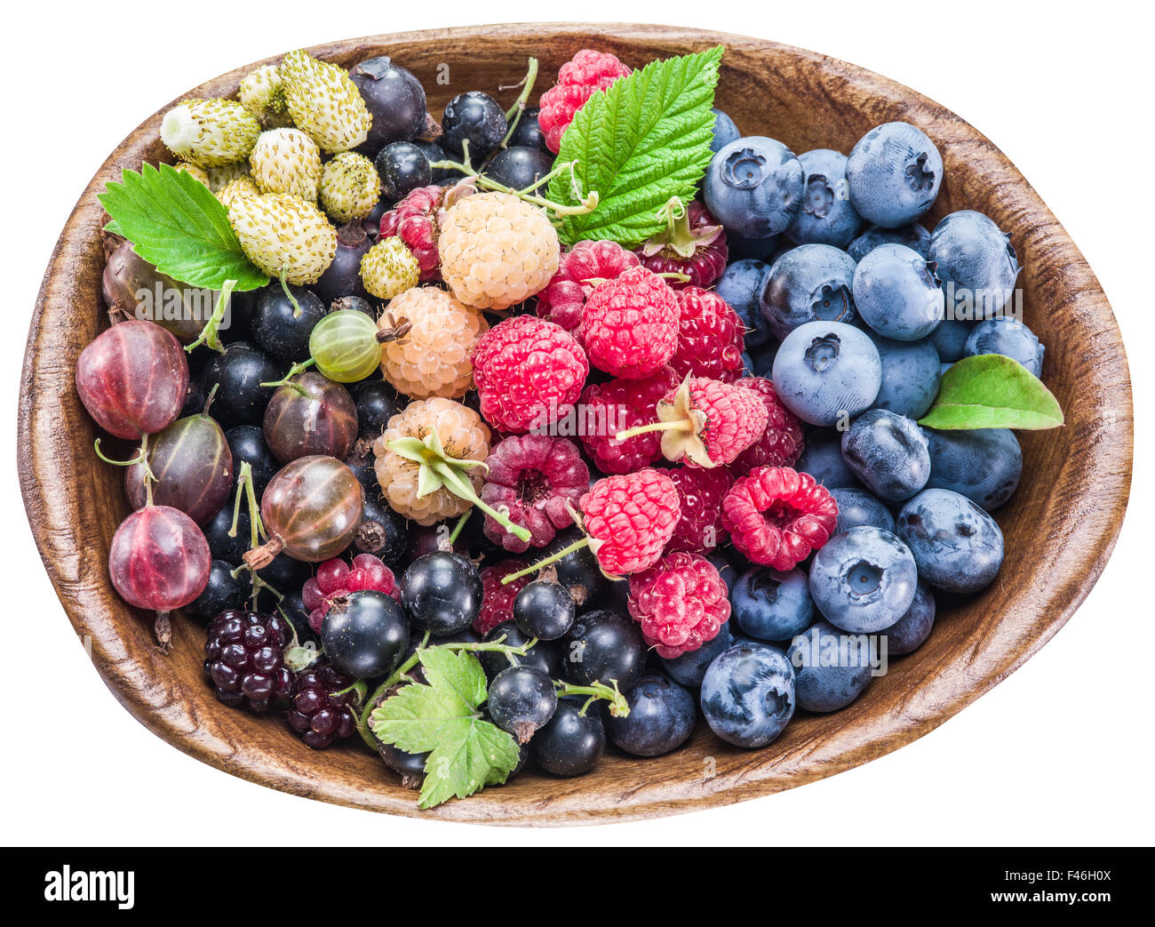 Ripe berries in the wooden bowl on white. File contains clipping paths ...