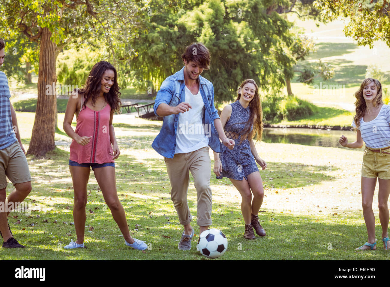 Happy friends in the park with football Stock Photo - Alamy