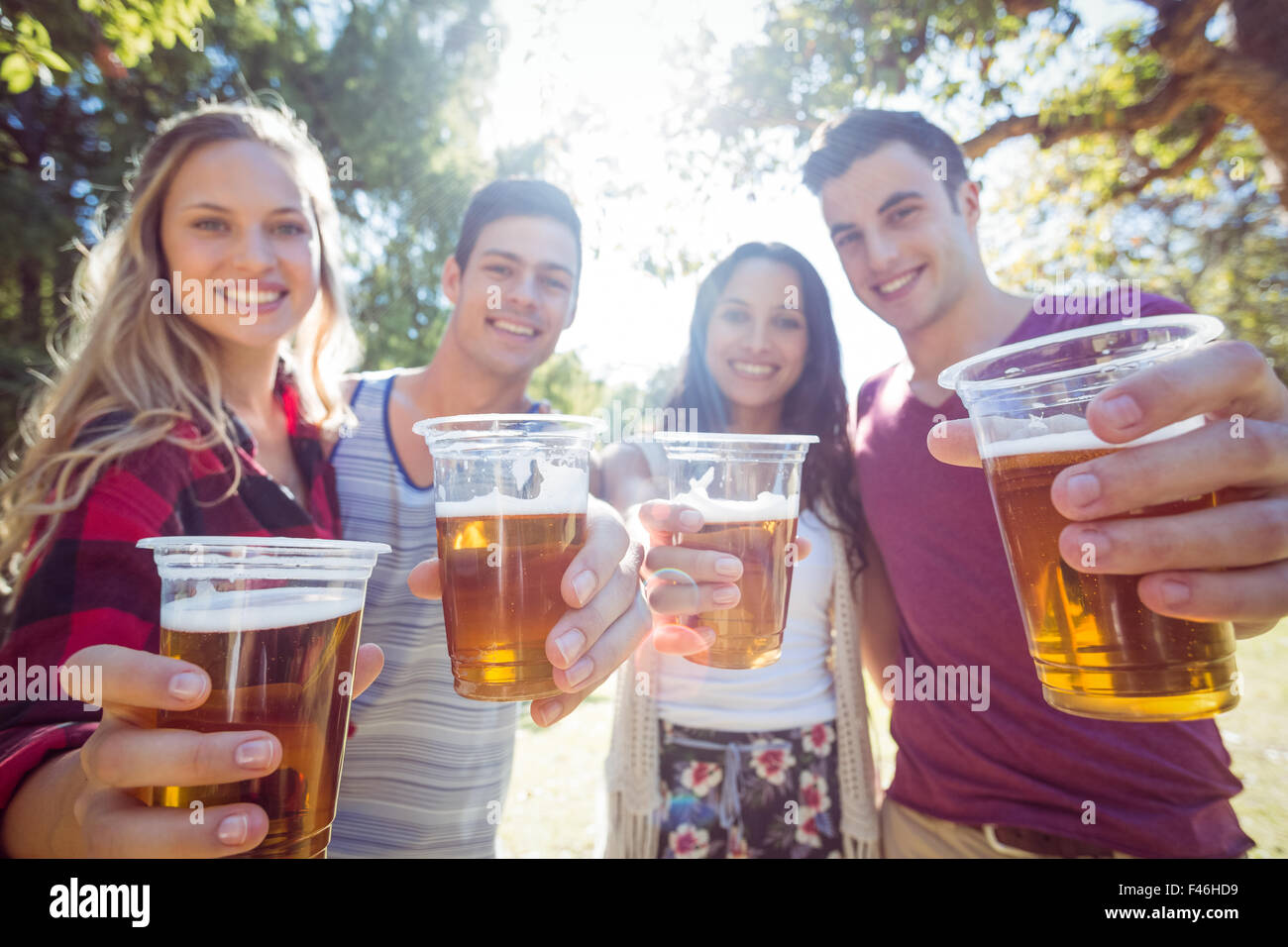 Happy friends in the park having beers Stock Photo - Alamy