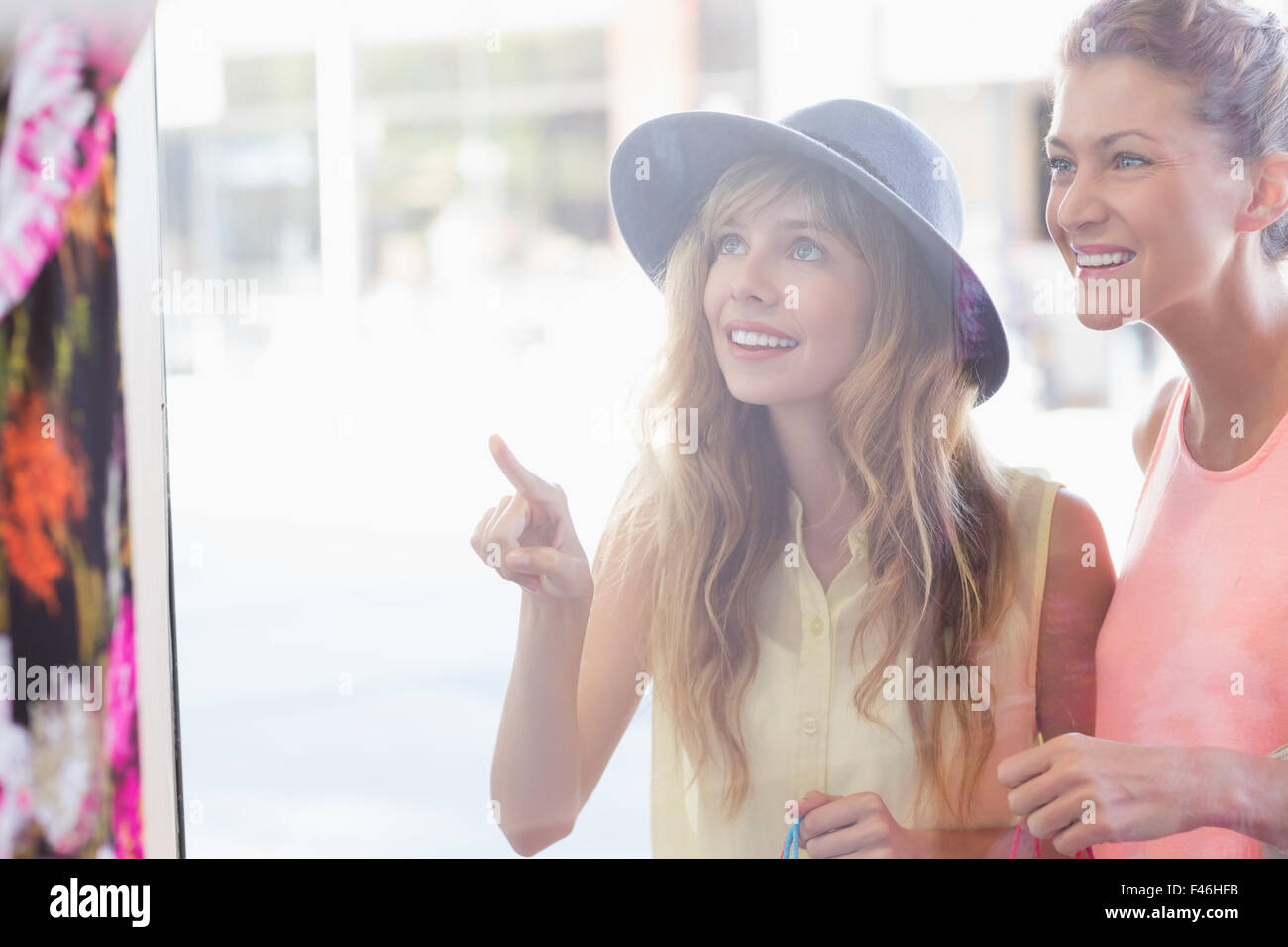 Beautiful woman pointing at something behind window Stock Photo - Alamy