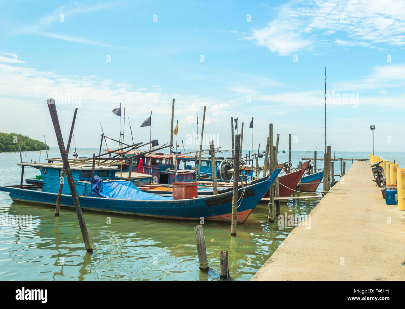 Traditional wooden boat at jetty with blue skies Stock Photo - Alamy