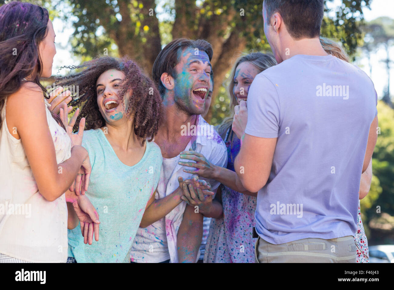 Friends throwing powder paint Stock Photo - Alamy