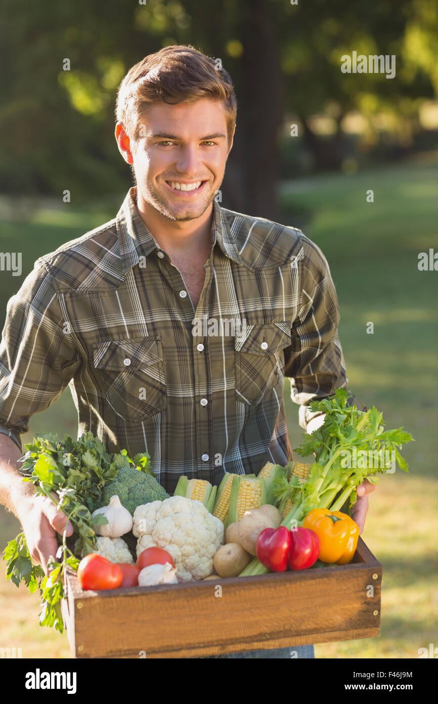 Smiling man carrying box of vegetables Stock Photo - Alamy