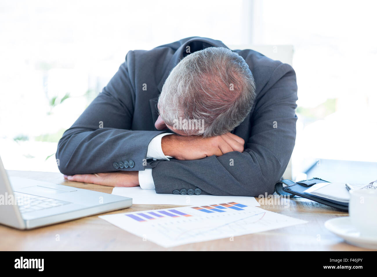 Tired businessman resting on desk Stock Photo - Alamy