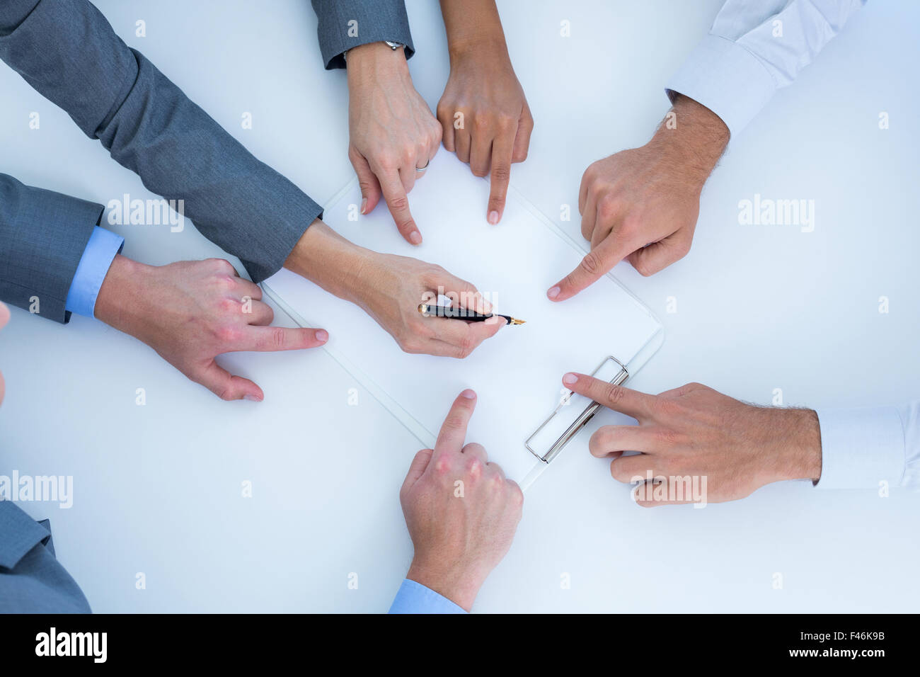 Business team pointing clipboard Stock Photo - Alamy