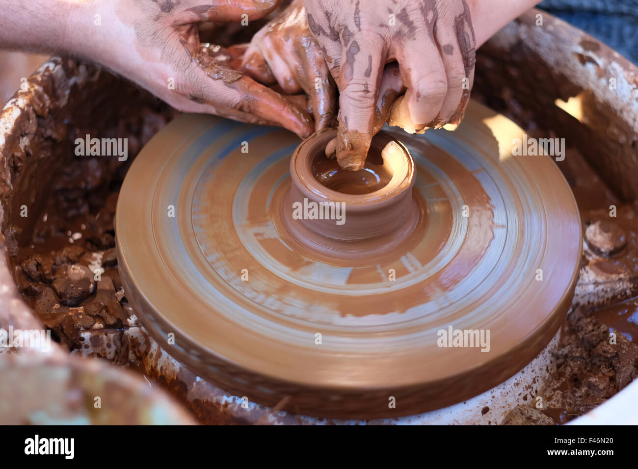 Hands working on pottery wheel Stock Photo - Alamy