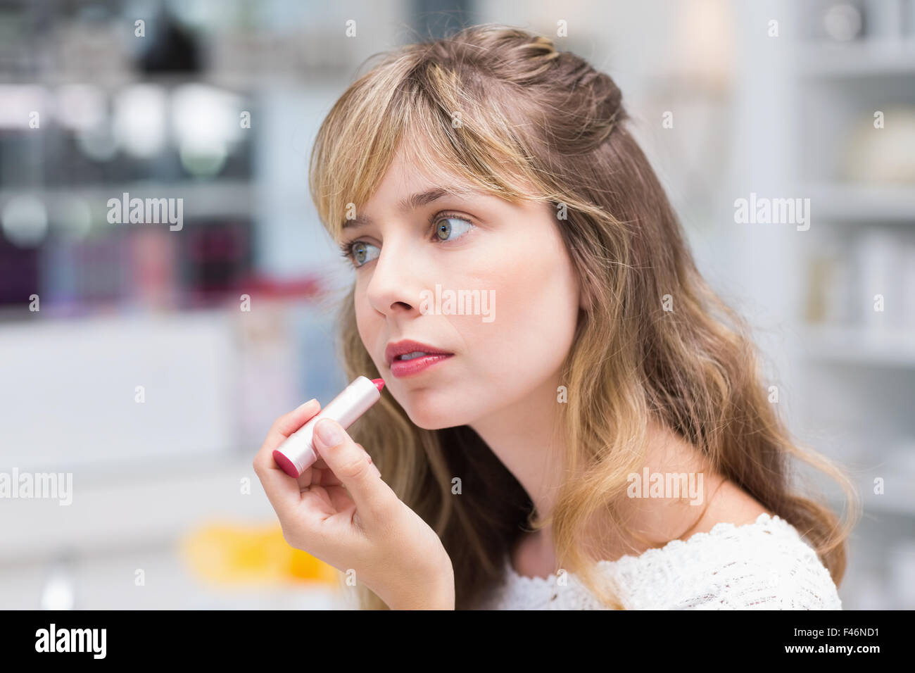 Beautiful costumer putting on makeup Stock Photo - Alamy