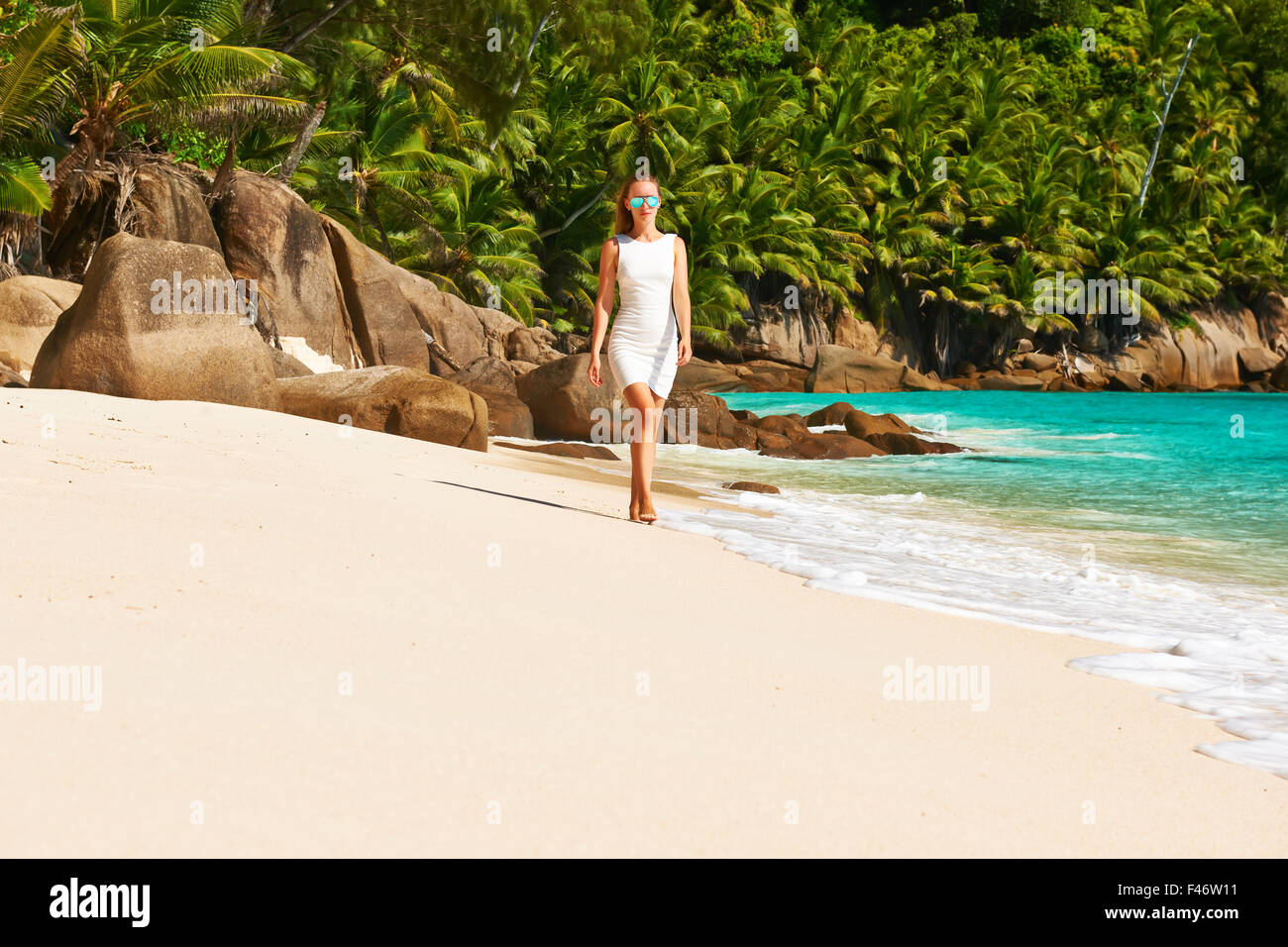 Woman wearing dress on beach at Seychelles Stock Photo - Alamy