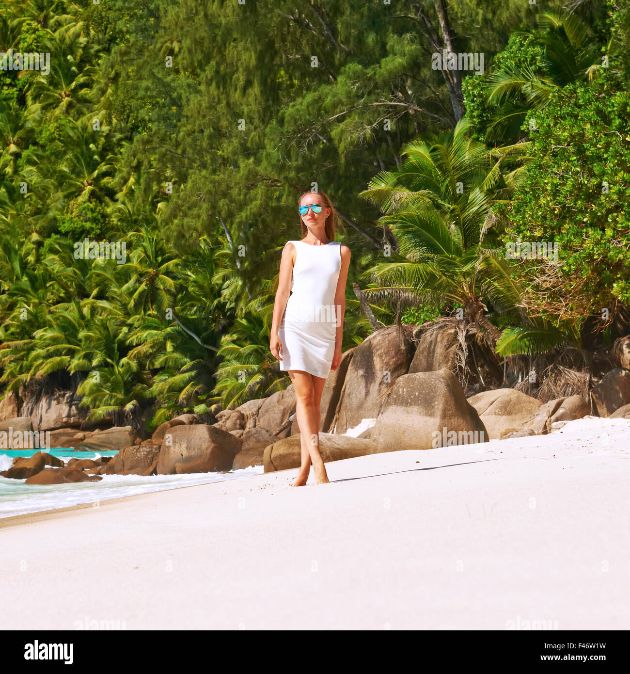 Woman wearing dress on beach at Seychelles Stock Photo - Alamy