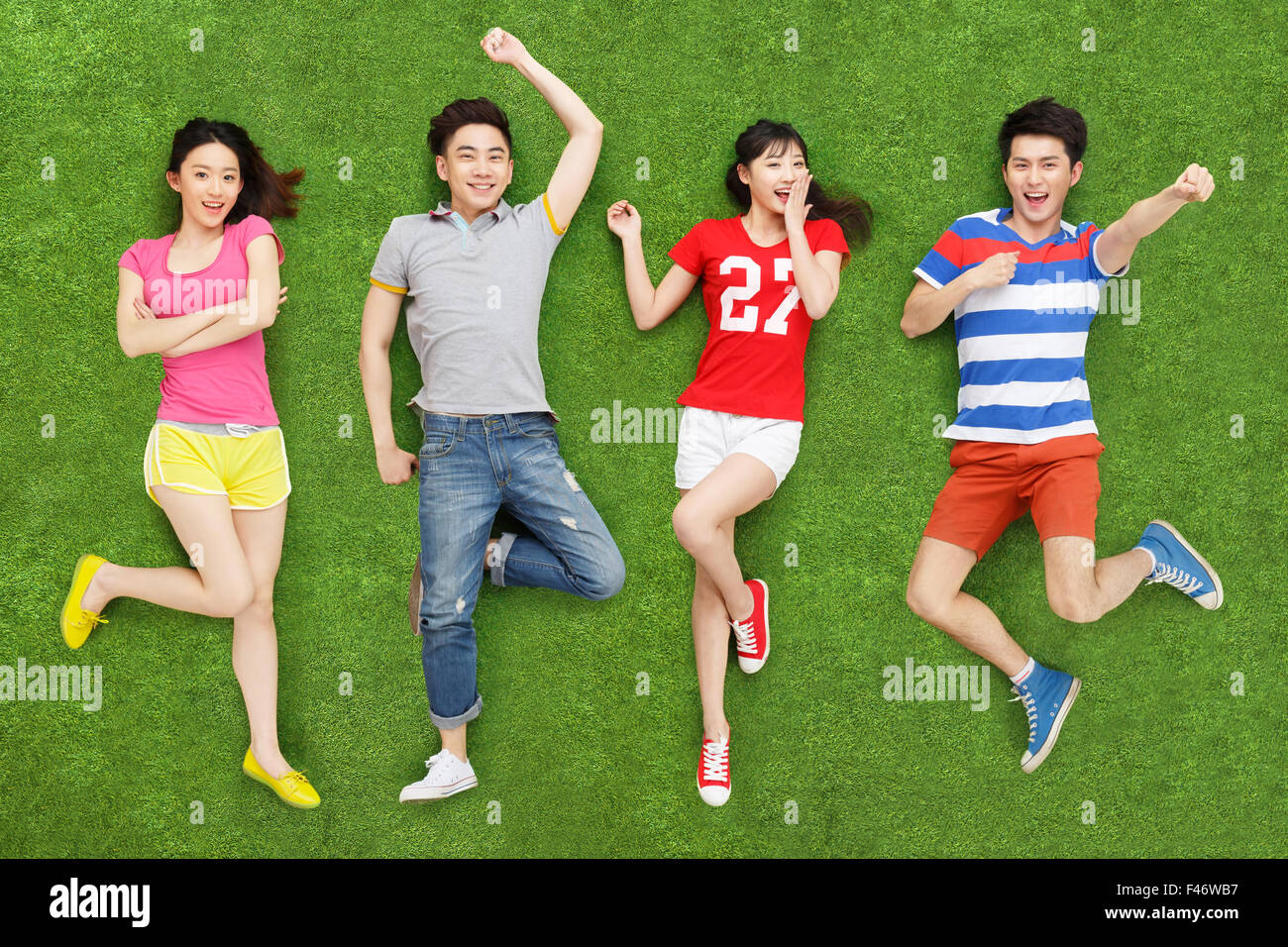 Four young people on grass Stock Photo - Alamy
