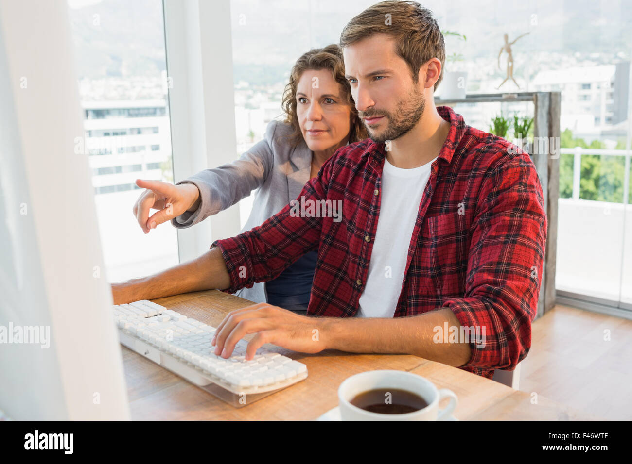 Creative business partners working on computer together Stock Photo - Alamy