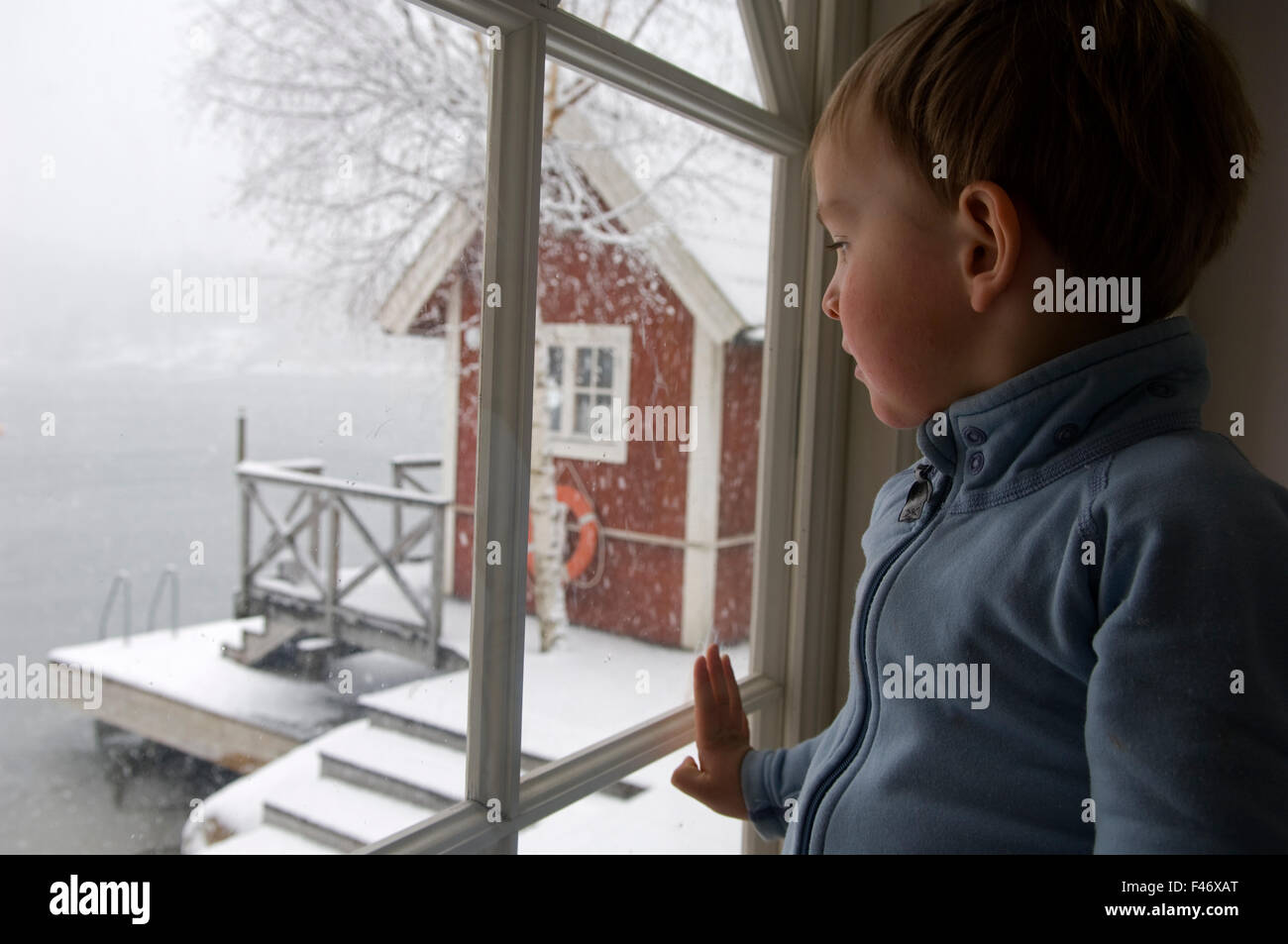 A child looking out a window a winter day, Sweden Stock Photo - Alamy