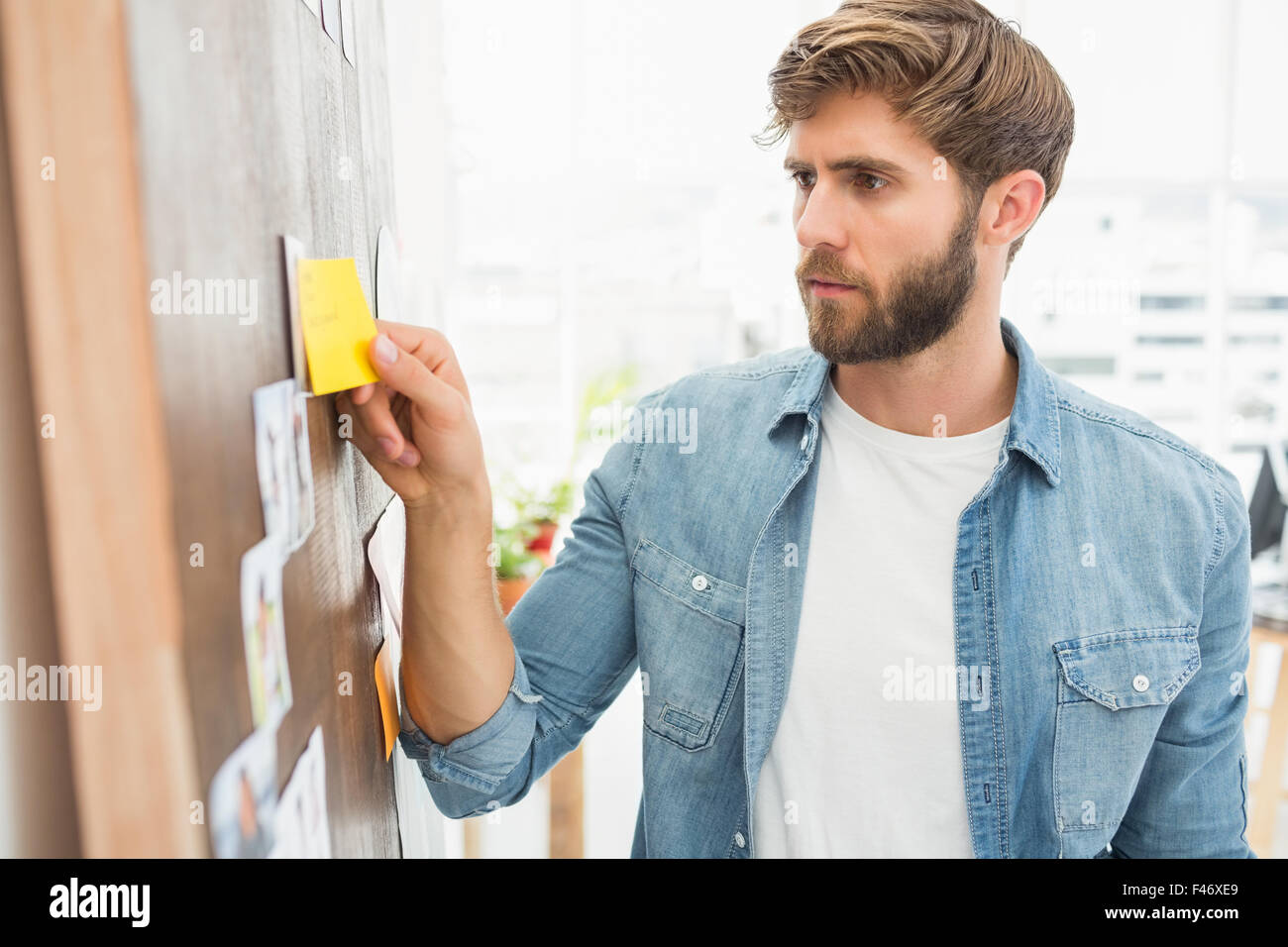 Puzzled businessman looking post its on the wall Stock Photo - Alamy