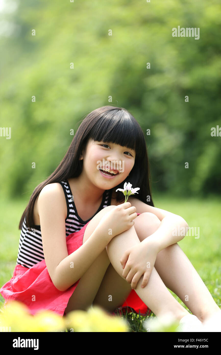 Portrait of girl sitting on grass Stock Photo - Alamy