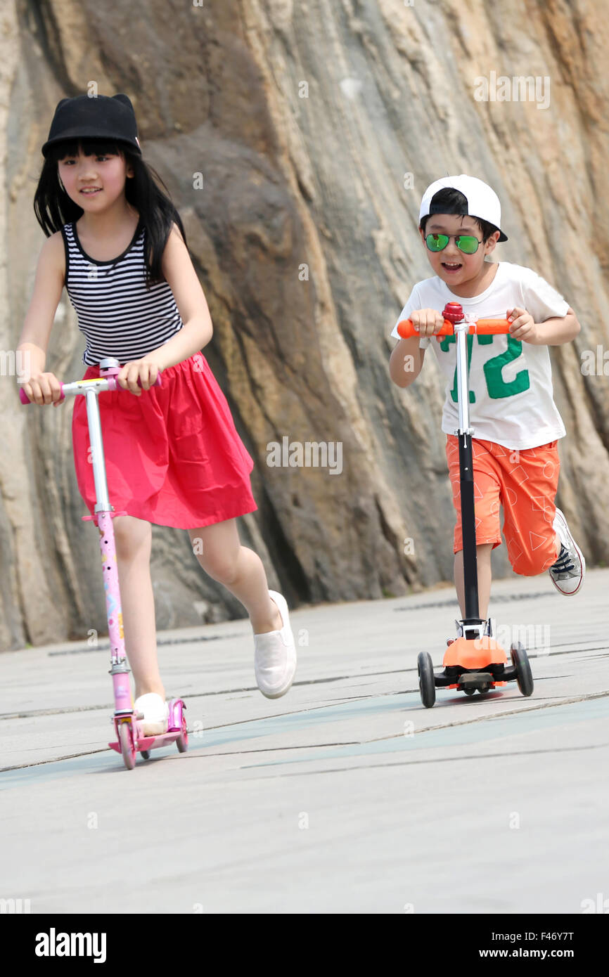 Girls riding scooter Stock Photo - Alamy