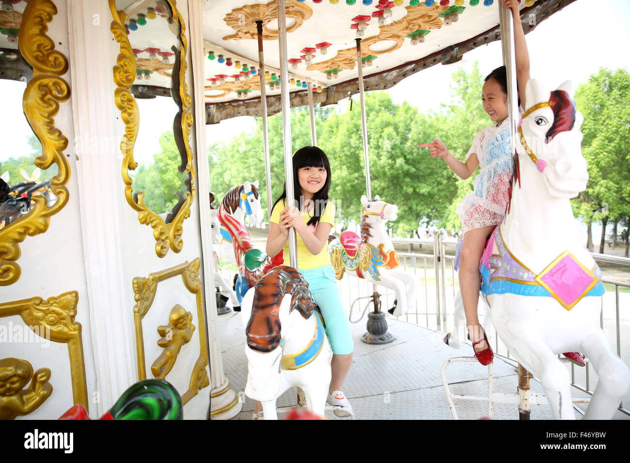 Girls on carousel Stock Photo - Alamy