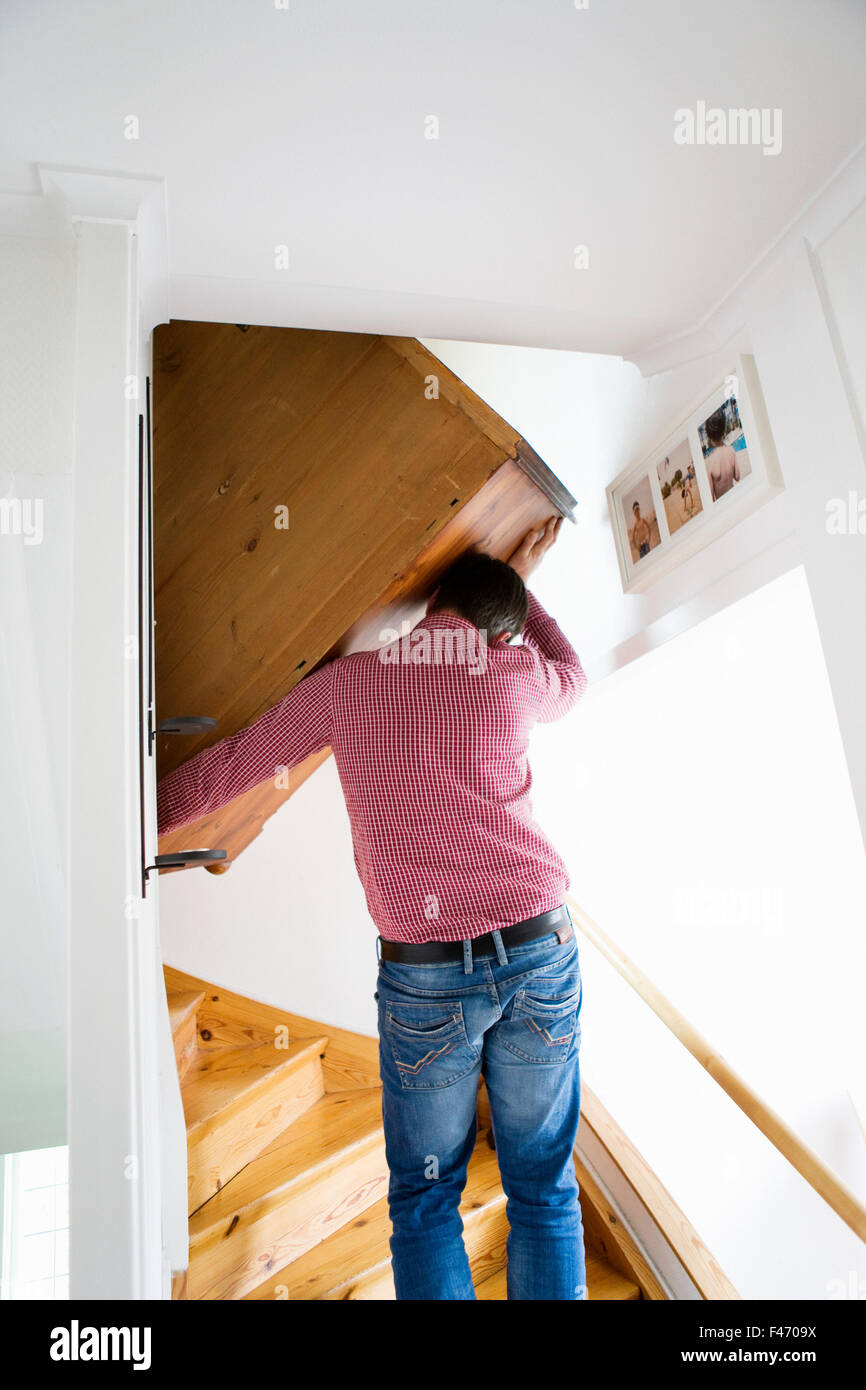 A cupboard is being carried down the stairs Stock Photo - Alamy