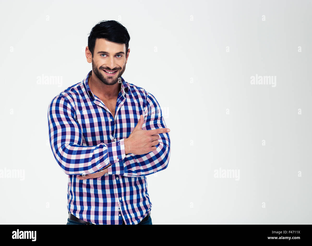 Portrait of a cheerful man pointing finger away isolated on a white ...