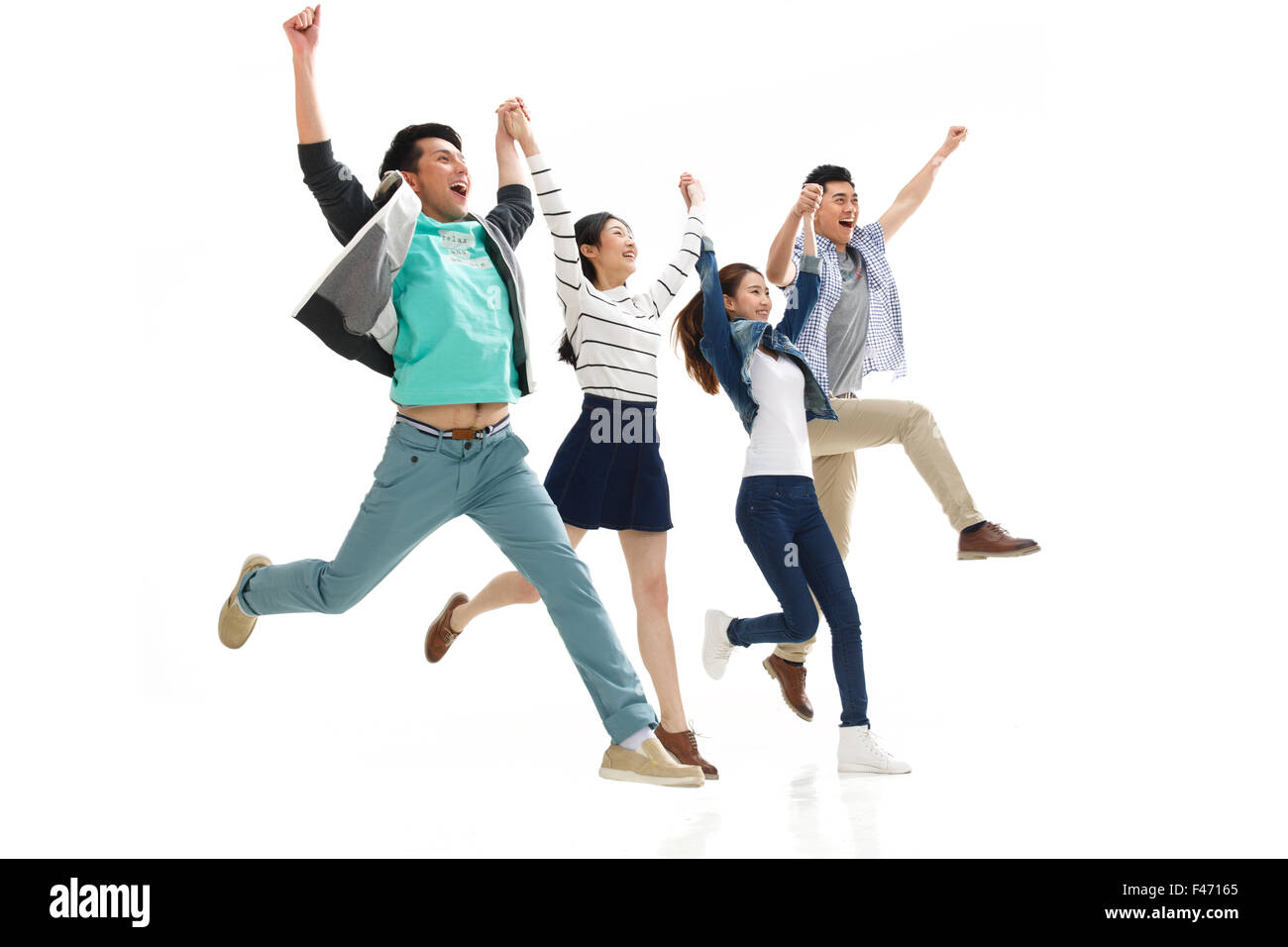 Portrait of four young people jumping Stock Photo - Alamy