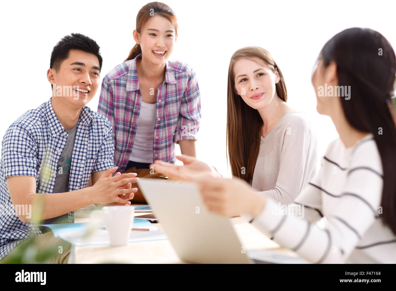 Young people around table Stock Photo - Alamy