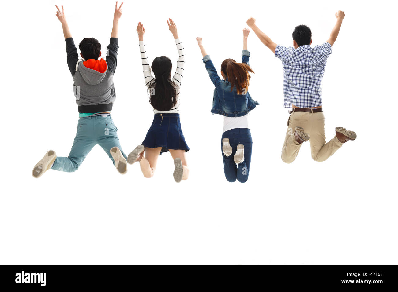 Portrait of four young people jumping Stock Photo - Alamy