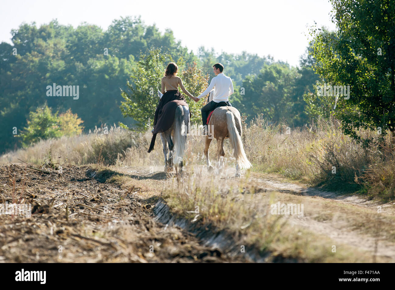 Young couple in love riding a horse Stock Photo - Alamy