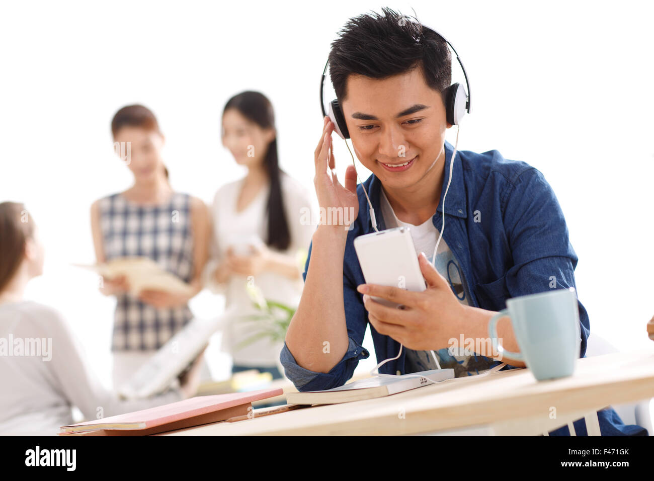Young man listening to music in classroom Stock Photo - Alamy
