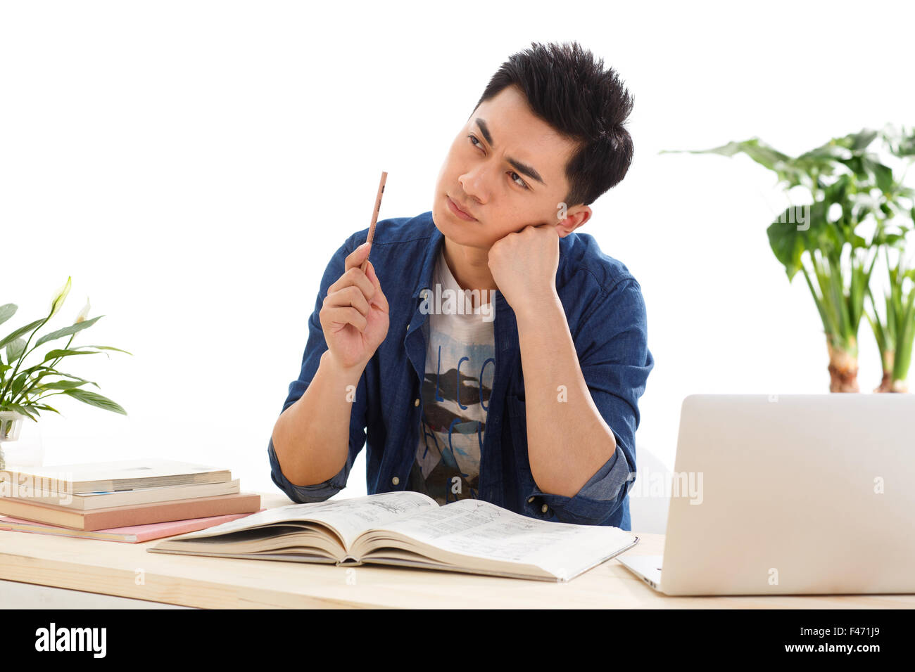 Man at table holding pen, resting head on hand Stock Photo - Alamy