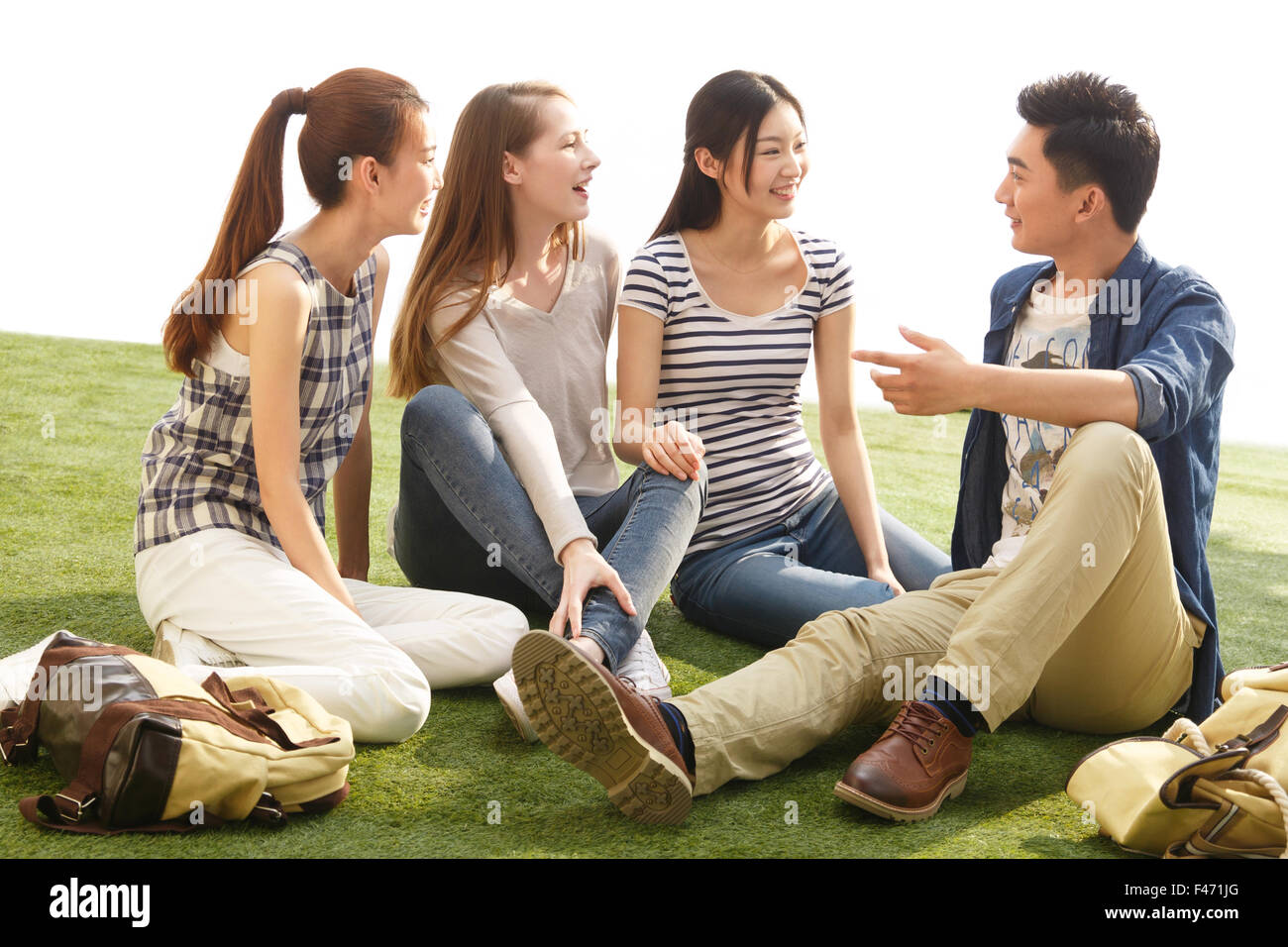 Young people sitting on lawn talking Stock Photo - Alamy
