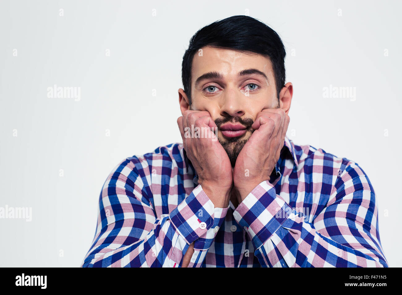 Portrait of a pensive man looking at camera isolated on a white ...