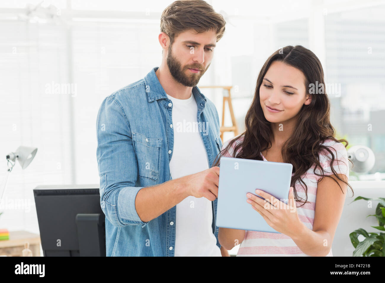 Casual business partners holding tablet Stock Photo - Alamy