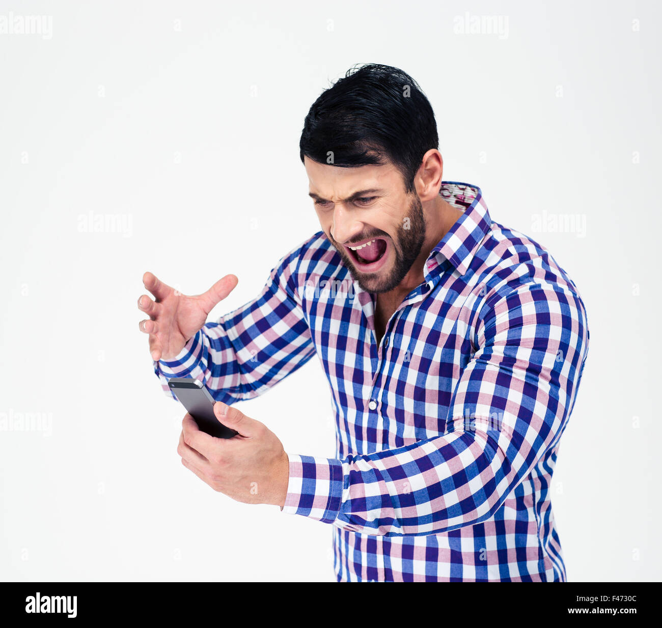 Portrait of angry man shouting on smartphone isolated on a white ...