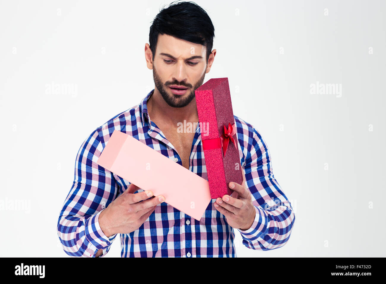 Portrait of a young man opening gift box isolated on a white background ...