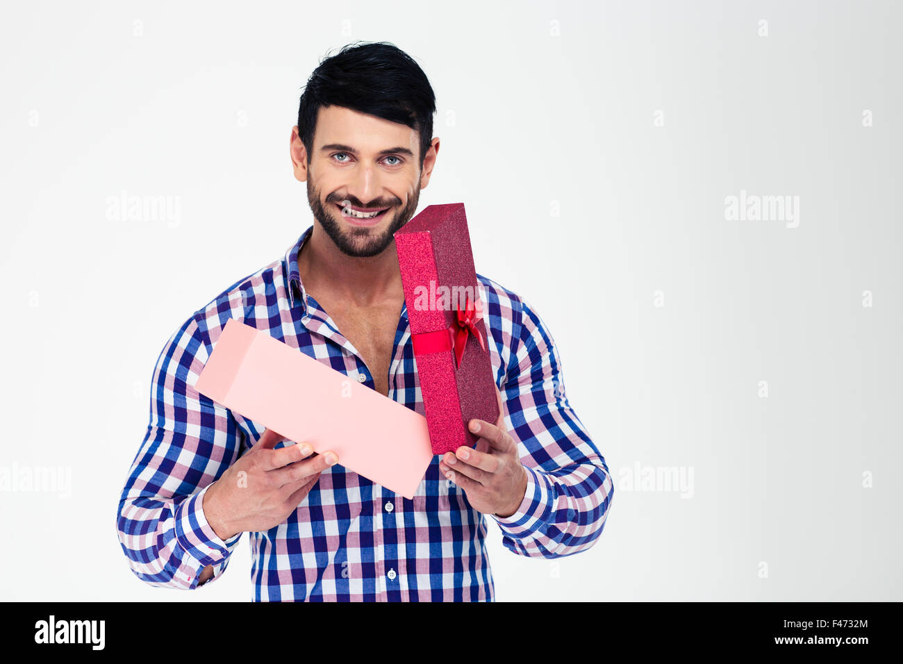 Portrait of a happy man opening gift box isolated on a white background ...