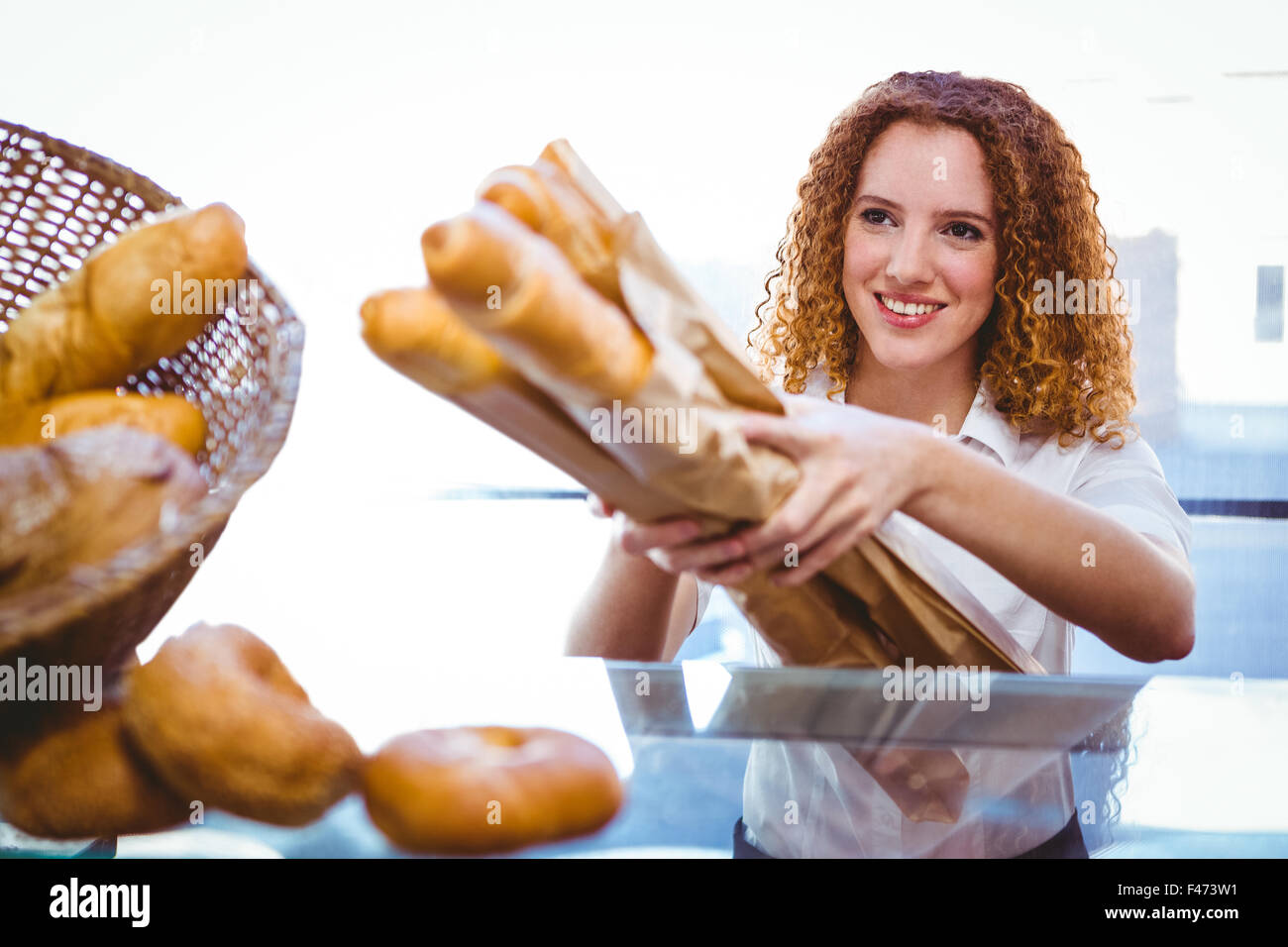 Pretty barista holding loaf of bread Stock Photo - Alamy