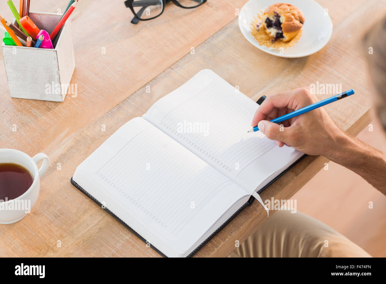Man writing notes on diary Stock Photo - Alamy