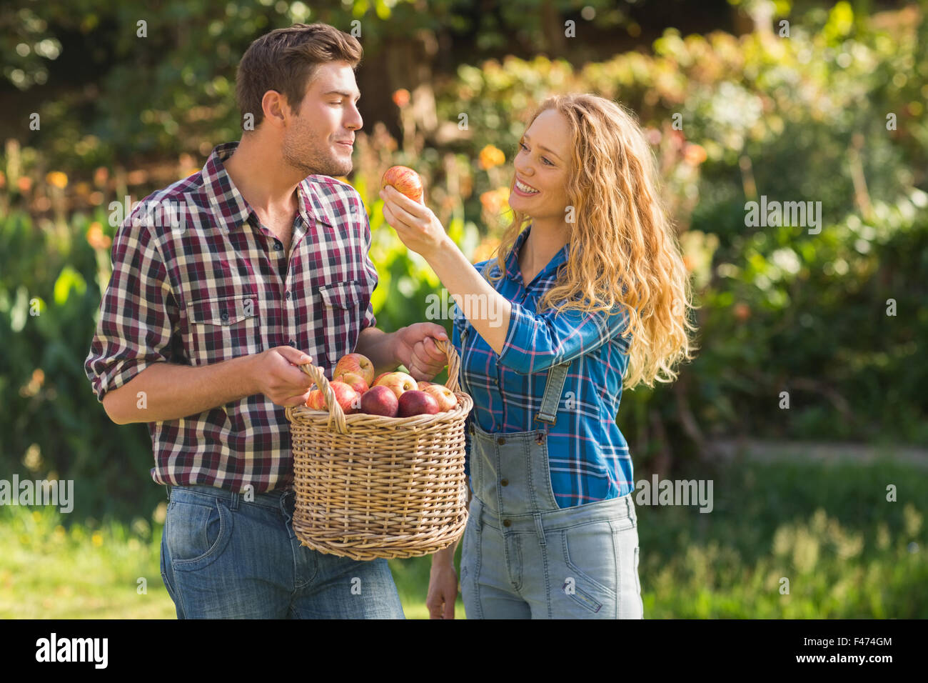 Happy woman giving apple to her husband Stock Photo - Alamy