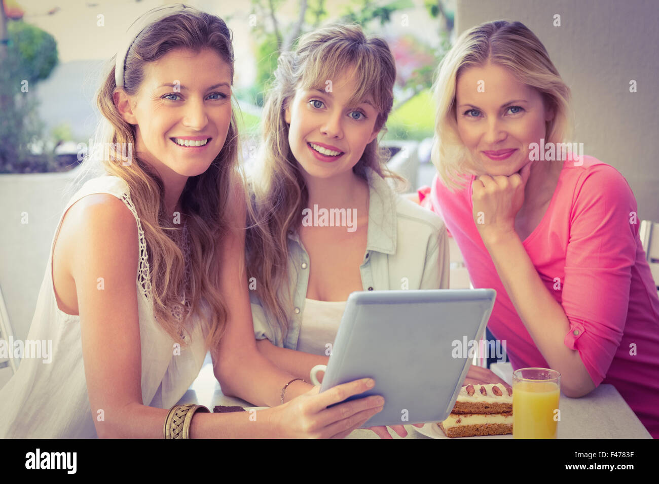 Beautiful women holding tablet and smiling at the camera Stock Photo ...