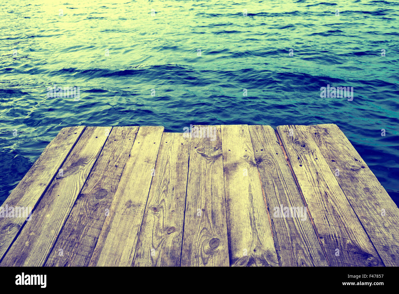 Blue water with empty wooden platform Stock Photo - Alamy