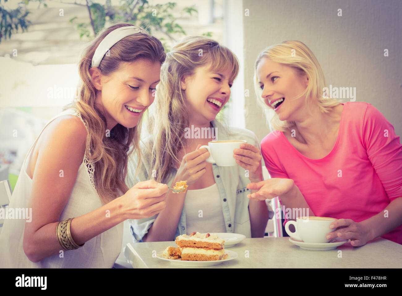 Beautiful women smiling and eating cake Stock Photo - Alamy