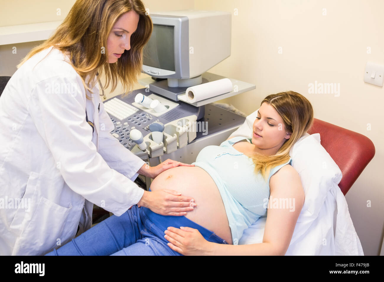 Doctor looking at pregnant patient Stock Photo - Alamy
