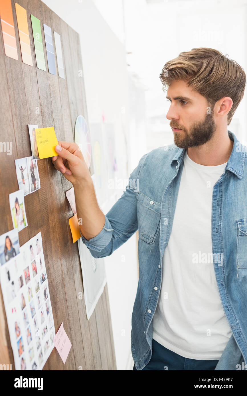 Puzzled businessman looking post its on the wall Stock Photo - Alamy