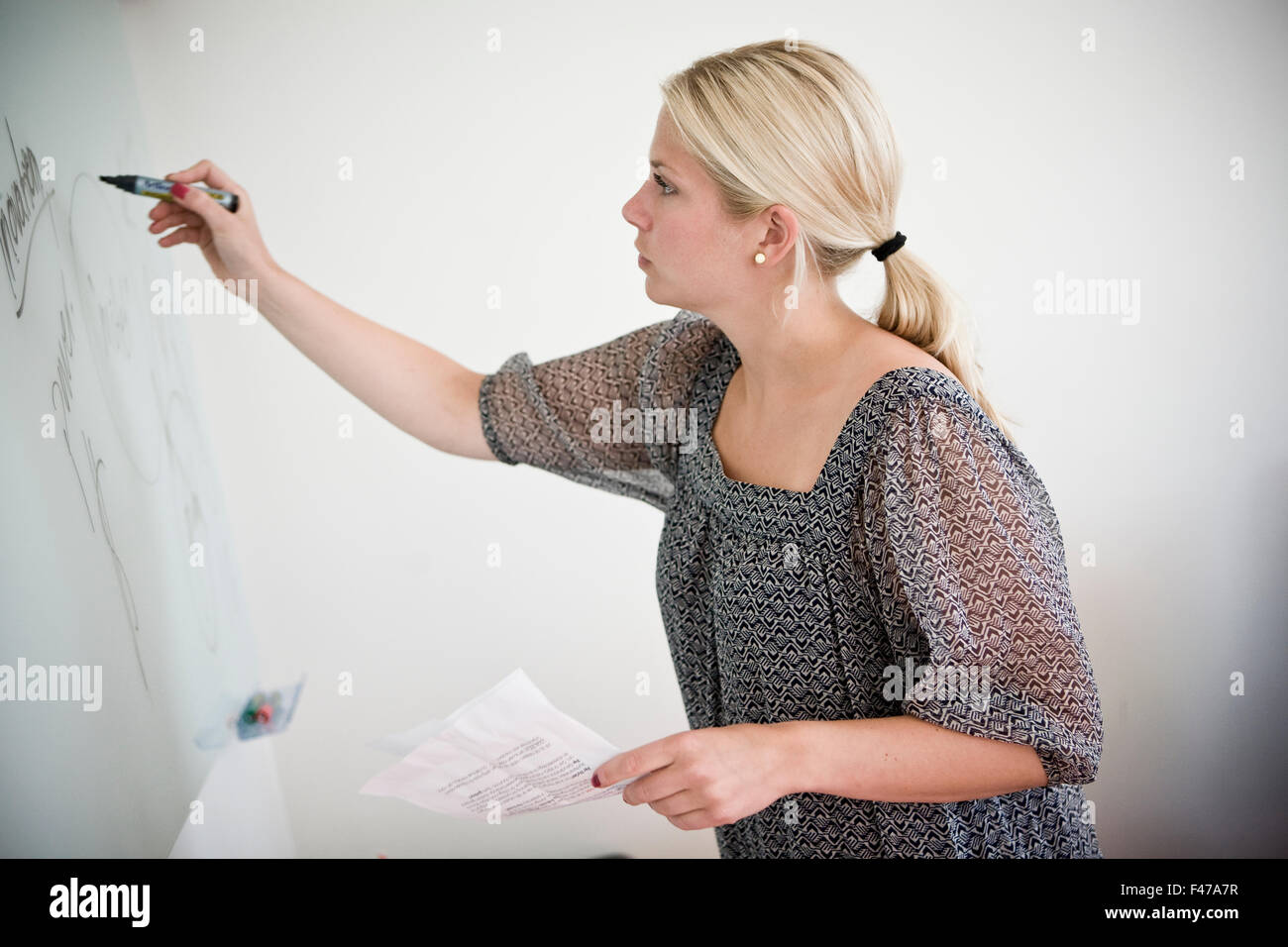A woman writing on a whiteboard, Sweden Stock Photo - Alamy